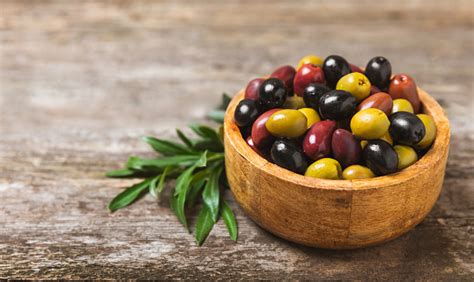 배경에 녹색 빨간색 및 검은색 올리브 세트입니다 그릇에 담긴 다양한 종류의 올리브와 신선한 올리브 잎 채식주의 올리브 과일 텍스트의 위치 공간을 복사합니다 개체 그룹에 대한