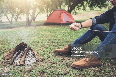 젊은 사람 요리는 마시마로 숲에서 캠프 파이어에 사탕 하이킹 하이킹 및 개념사람들이 행복 한 휴식 캠핑 관광에 대한 스톡 사진