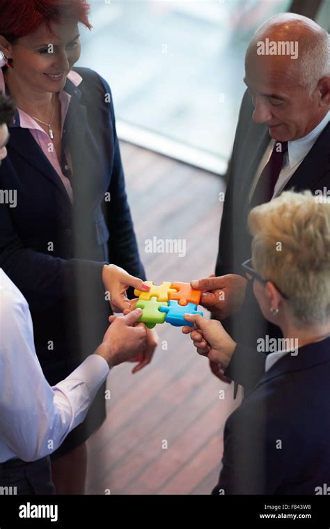 Business People Group Assembling Jigsaw Puzzle And Represent Team