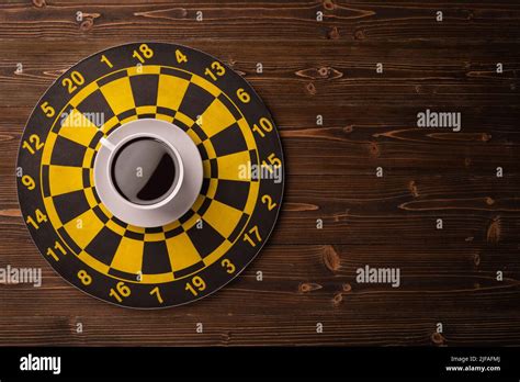 Top View Cup Of Coffee On Dart Board On Brown Wooden Table Background Composition With Free