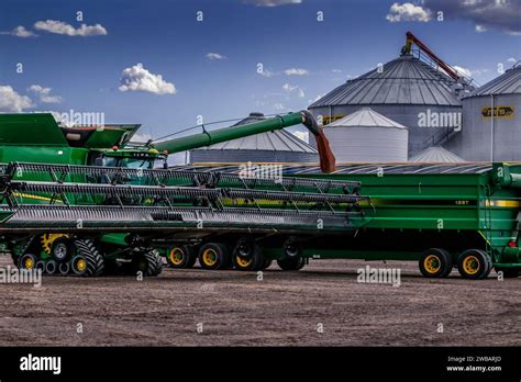 A Large Tractor Trailer Is Transporting A Grain Mill On Its Back With