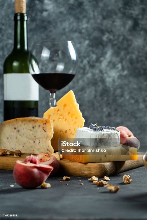레드 와인과 치즈 도마에 견과류 라반더 무화과 복숭아치즈의 다른 유형 로맨틱 한 저녁 식사 디자인을 위한 공간을 복사합니다 어두운 배경 소프트 포커스 0명에 대한 스톡 사진