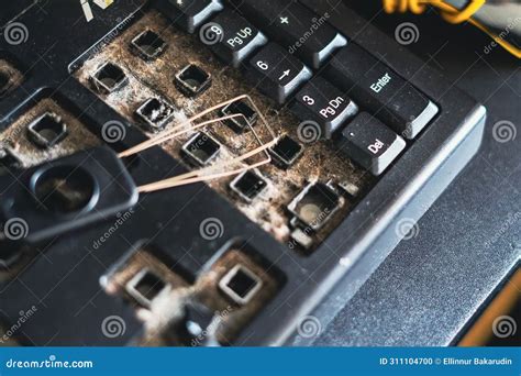 Dirty Qwerty Keyboard Full Of Dusts And Debris On The Table Cleaning The Computer Stock Photo