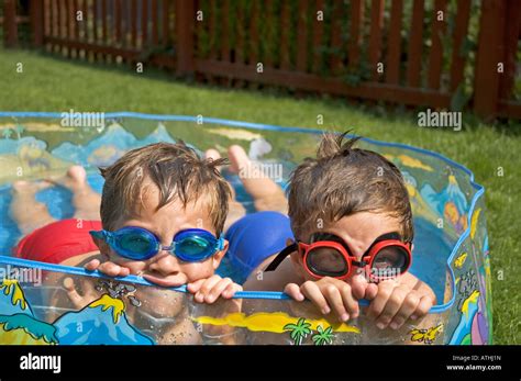 Zwei Kleine Jungs In Einem Planschbecken Im Garten Liegend