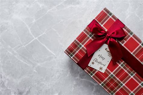 새장에 있는 빨간 선물 상자와 회색 대리석 배경에 메리 크리스마스라는 글자가 새겨진 라벨 크리스마스 휴일 2023 가족 및