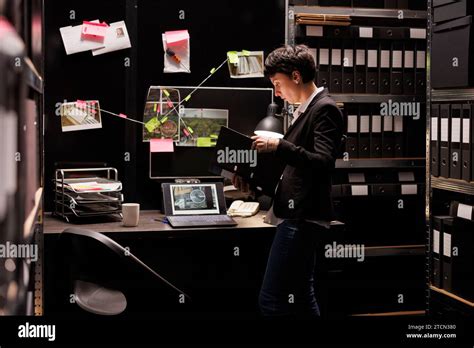 Police Officer Investigating Fraude Case Analyzing Confidential Report Working Late At Night In