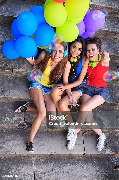 Teman Ceria Dengan Headphone Dan Balon Duduk Di Tangga Foto Stok