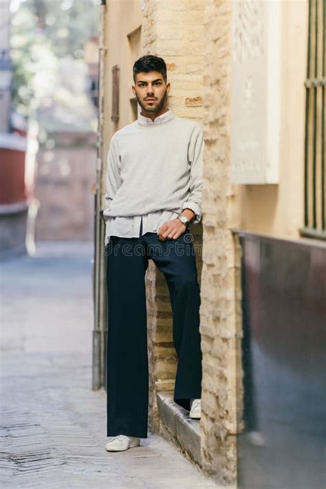 Stylish Man Posing While Looking At The Camera With A Cocky Expression