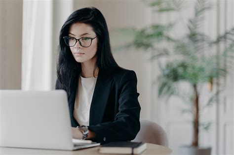 젊은 진지한 사업가는 사무실에서 직장에서 노트북 컴퓨터와 함께 작동 광학 안경과 공식 의상을 입고 화면에 집중 직업 직업 사업 개발 개념 25 29세에 대한 스톡 사진 및