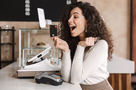 Mulher Sorrindo De Boca Aberta Segurando E Olhando O Cartão Da Swile