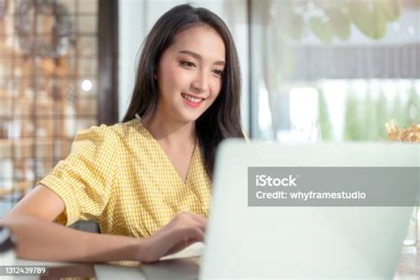 아름다운 매력적인 아시아 여성 신선도 는 행복과 집에서 노트북 커피 작업으로 일하는 쾌활한 아침을 미소 정원 보기 창 빛 정원