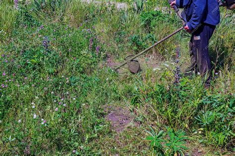 Premium Photo A Man Cuts And Mows The Grass Grass Cutting Work Worker
