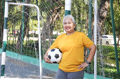 도시 야외 코트에서 축구를하는 활동적인 노인 여성 축구 공을 가진 아시아 노인 여성 건강한 생활 개념 55 59세에 대한 스톡