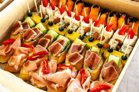 작은 샌드위치 에클레어 브루스케타와 함께 골판지 상자에 음식으로 음식을 맛보며 파티를 위한 뷔페를 즐기실 수 있습니다 0명에