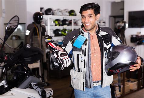 Cliente En Chaqueta Con Casco Es Elegir Guantes Imagen De Archivo