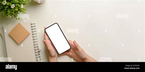 Top View Of Female Hands Holding Smartphone Include Clipping Path Screen On White Workspace