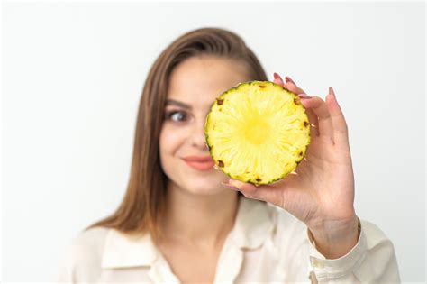 젊은 매력적인 꽤 멋진 백인 웃는 여자는 흰색 배경에 그녀의 눈을 덮고있는 반지 조각 파인애플을 들고 있습니다 건강한 식생활 개념 20 24세에 대한 스톡 사진 및 기타