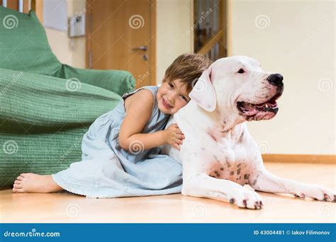 Niño Sonriente De La Muchacha En El Piso Con El Perro Imagen De Archivo