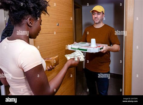 A Young Woman Is Paying For Pizza Delivery Girl Handing Cash To A