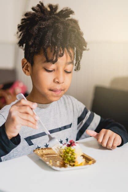 Niño Comiendo Comida En La Mesa Foto Premium