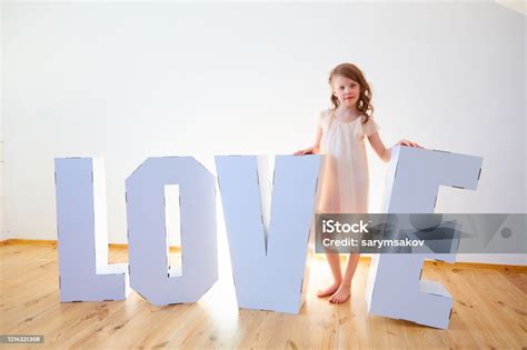 밝은 배경에 흰색 판지에서 단어 Love를 형성하는 큰 골판지 3d 서 편지와 함께 연주 소녀 7 세 관계 개념입니다 개념에