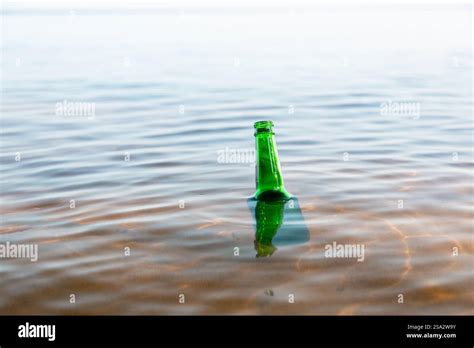 Green Glass Bottle Floating In A River Bottleneck Seen Over Water