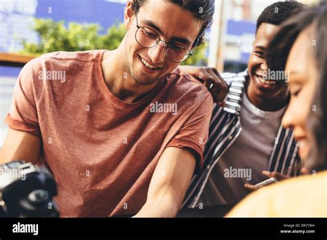 Young Guy Showing His Social Media Content On Digital Camera To Friends