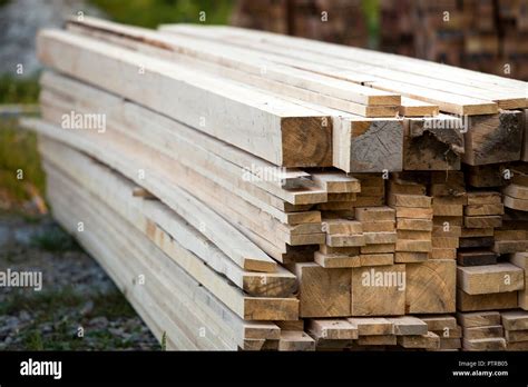 Stack Of Natural Brown Uneven Rough Wooden Boards On Building Site