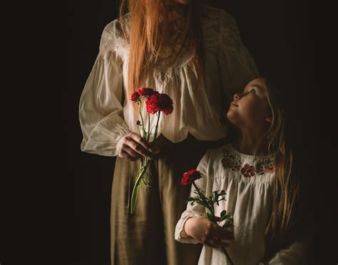 Premium Photo Midsection Of Mother And Daughter Holding Flowers