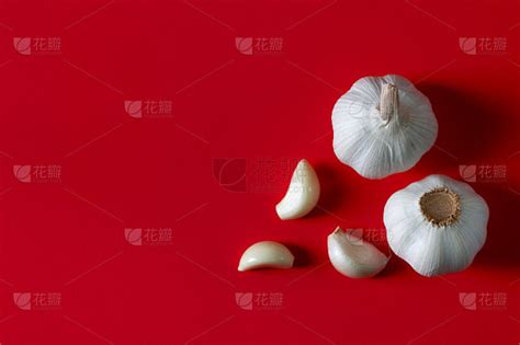 大蒜和蒜瓣在红色的纸背景