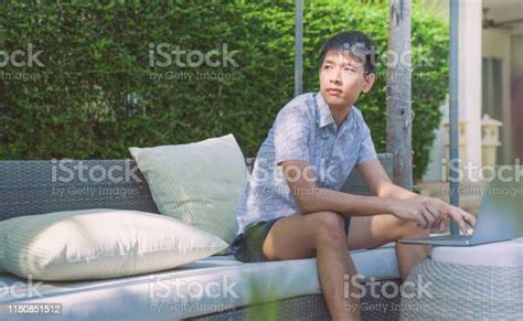 디지털 태블릿과 스마트 폰을 사용 하 여 젊은 비즈니스 아시아 남자는 집에서 자신의 작업을 수행 하 고 야외 수영장에서 자신의