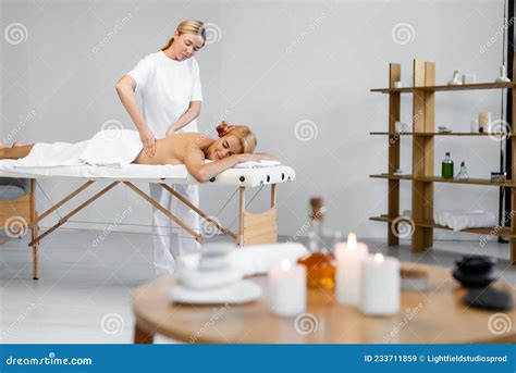 Masajista Frotando Aceite De Masaje En La Espalda Imagen De Archivo Imagen De Masajista