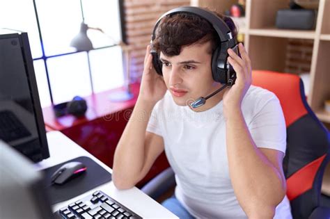 Non Binary Man Streamer Sitting On Table With Relaxed Expression At