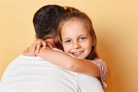 Padre Posando Hacia Atrás Abrazando A Su Hija Con Camisetas Casuales