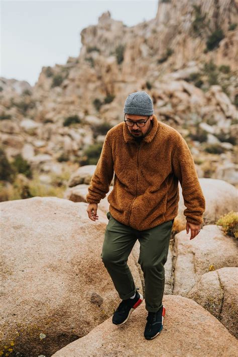 Man Wearing A Fleece Walking On Rocks Habilitate