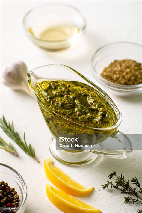 치미추리 소스에 그레이비 그릇에 흰색 배경 근처에는 다양한 향신료가 있습니다 올리브 오일 오레가노 파슬리로 만든 아르헨티나 채식