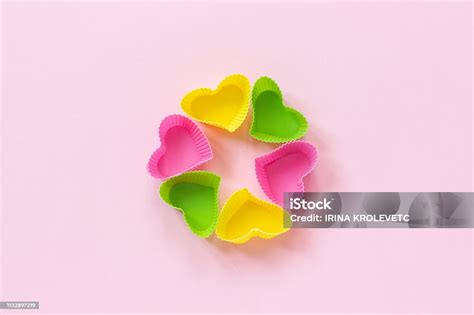 분홍색 종이 배경에 컵 케이크를 베이킹 하기 위한 컬러 실리콘 심장 모양의 금형 접시 레터링 텍스트 또는 디자인 평면도 복사