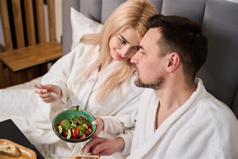 Cute Blonde And Her Husband Are Having Breakfast In Hotel Room Stock