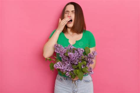 Young Sick Girl With Brown Hair Holding Bouquet Of Lilac Flowers