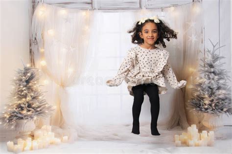 4 Year Old Latina Girl With Curly Hair Jumps On The Bed In Excitement