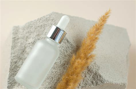 에센셜 오일 또는 세럼과 건조한 팜파스 허브가 자연스러운 흰색 연단에 있습니다 베이지색 배경에 피펫이 있는 젖빛 병 0명에 대한 스톡 사진 및 기타 이미지 Istock