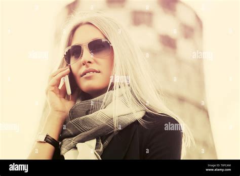 Blond Business Woman In Sunglasses Using Cell Phone Walking Outdoor