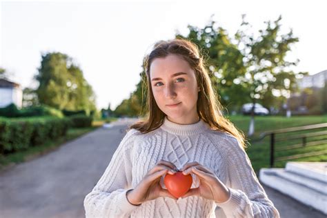 아름다운 어린 여학생 소녀는 공원에서 여름 야외에서 그녀의 손에 빨간 장난감 마음을 들고 행복한 미소 이 컨셉은 사랑 발렌타인 데이 기부 및 어린이에게 도움을 줍니다 가정용