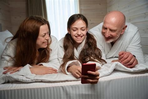 Cheerful Teenage Girl Spending Time With Mom And Dad Indoors Stock