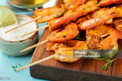 그릴에 구운 새우 꼬치 또는 랑구스틴과 라임 마늘 소스를 연한 파란색 콘크리트 배경에 얹어 드실 수 있습니다 해산물 갑각류에 대한 스톡 사진 및 기타 이미지 Istock