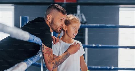 권투 링에 서서 젊은 문신을 한 권투 코치는 체육관에서 귀여운 소녀를 가르칩니다 사진 Unsplash의 우크라이나 이미지