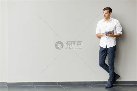靠墙的平板电脑的男人高清图片下载 正版图片503487362 摄图网