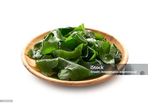 Laminaria 나무 접시에 해초 흰색 배경에 격리되어 있습니다 신선한 Laminaria 또는 다시마 나무 접시에 해초 흰색