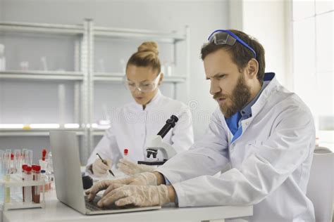 Concentrated Scientist Typing Laptop Keyboard Working On Research