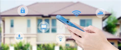 hand using mobile phone for smart home automation control app over blur